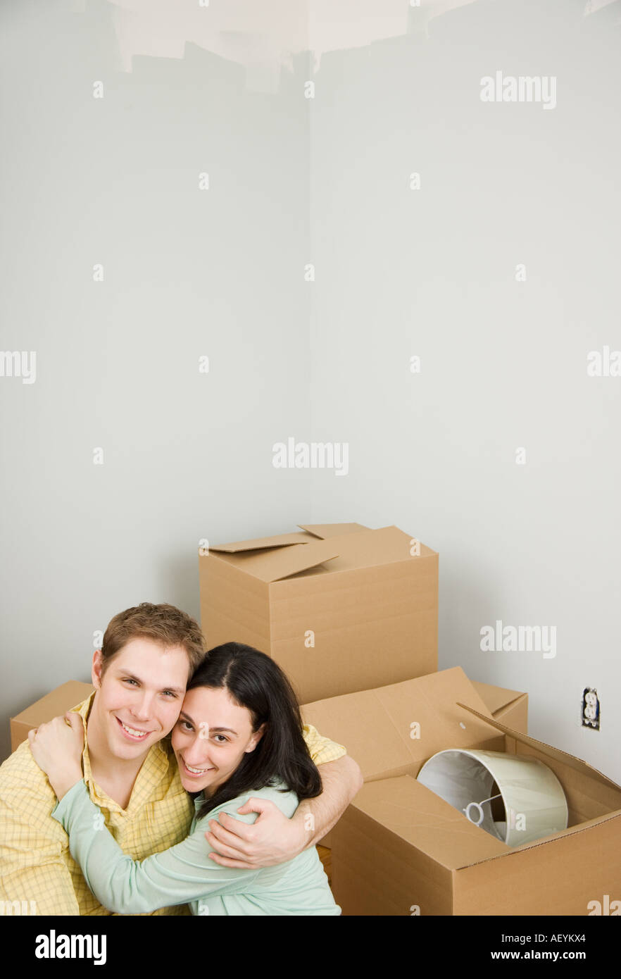 Couple hugging next to boxes in new house Stock Photo - Alamy