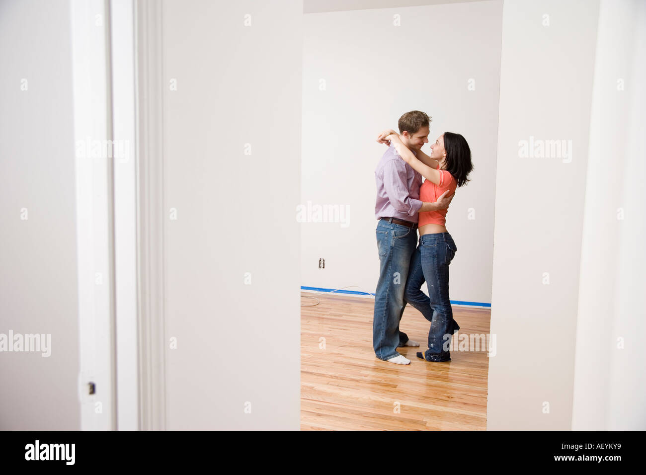 Couple hugging in empty new house Stock Photo - Alamy