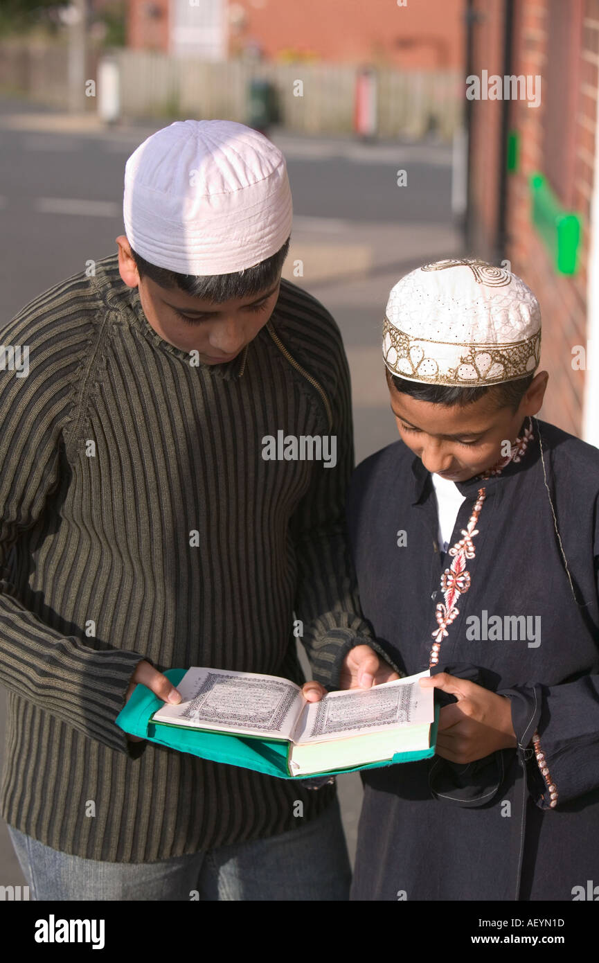 young asian muslim boy reads from the Koran outside a mosque in Beeston ...