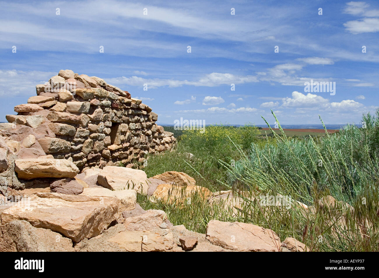 High atop a Colorado bluff an indian ruin is framed against a blue sky ...
