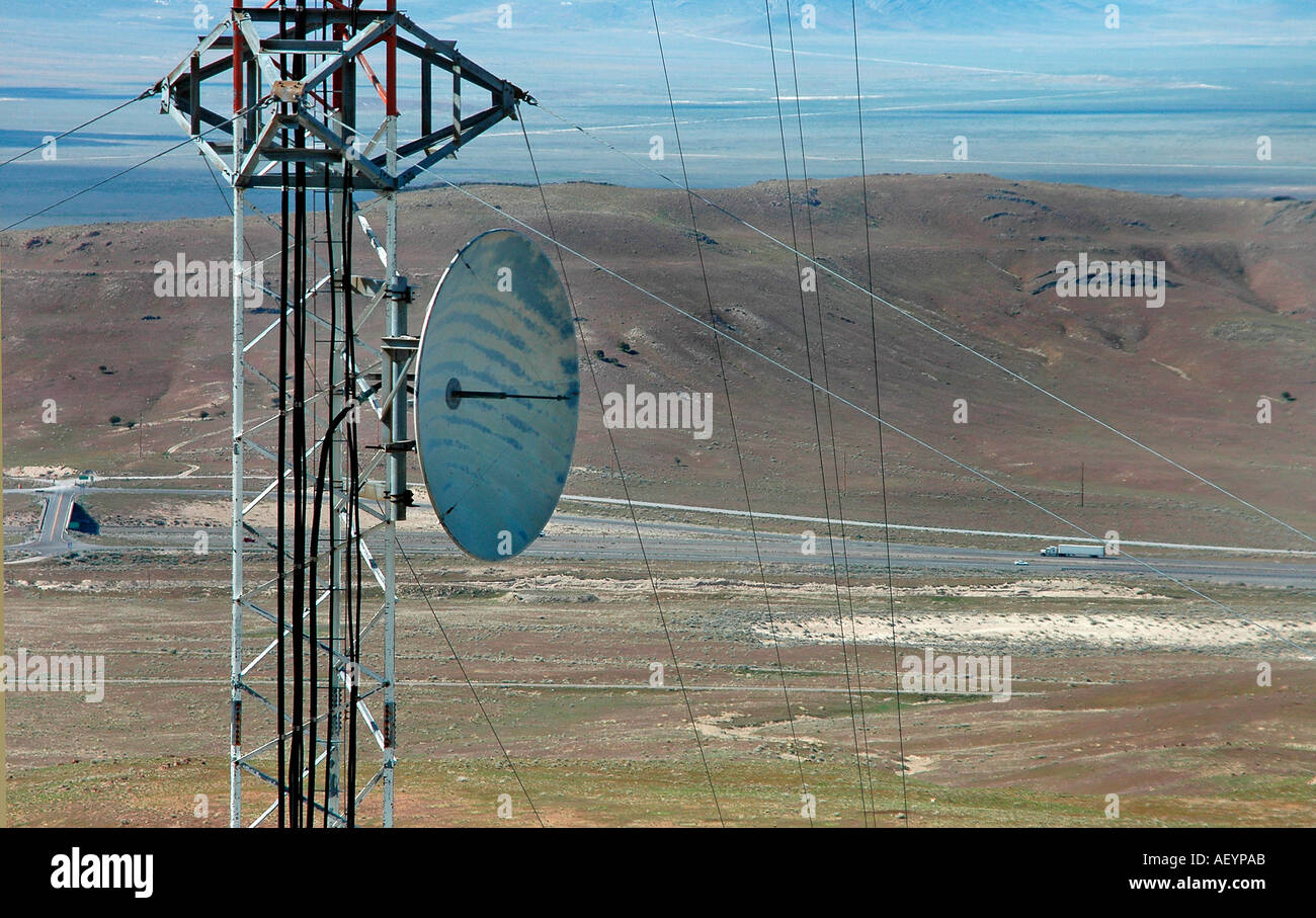 medium shot of a parabolic dish from a mountain top looking down at ...