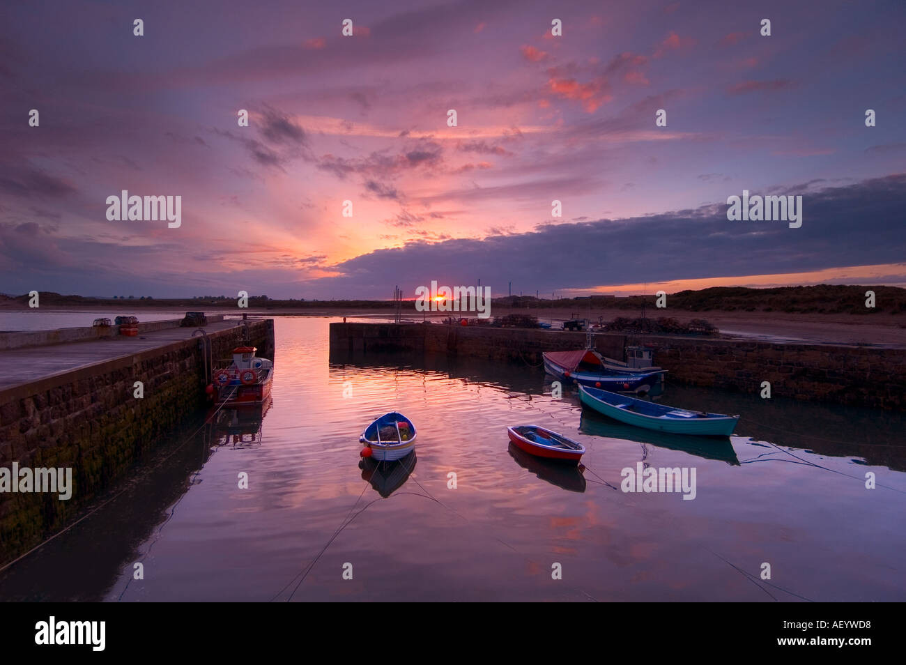 Beadnell Harbour sunset with boats Stock Photo - Alamy