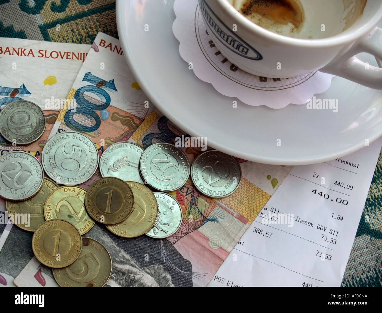 money from Slovenia Tollar on a table of a café with a receipt and ...