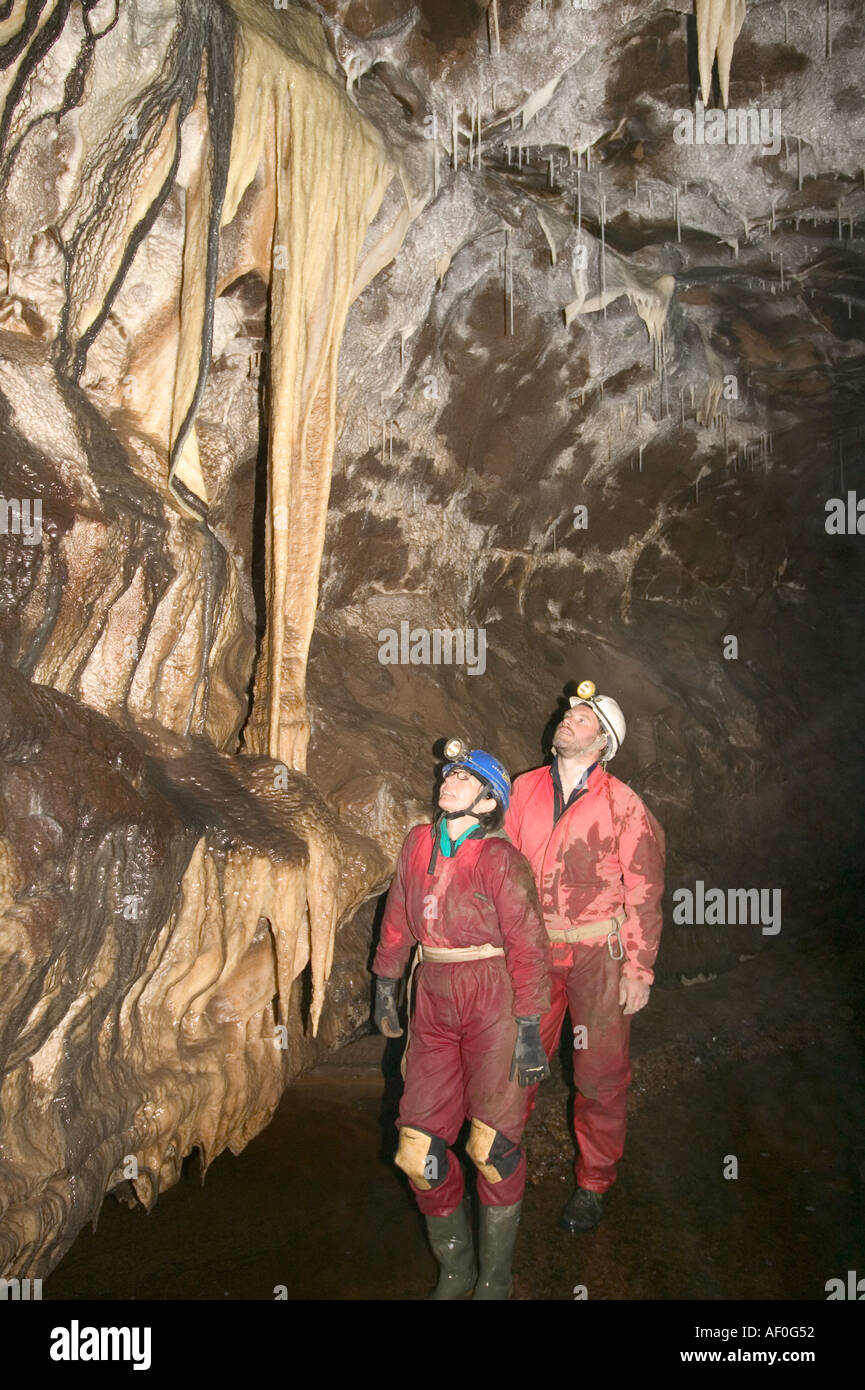 man and women caver inspect formations in the newly discovered Notts II ...