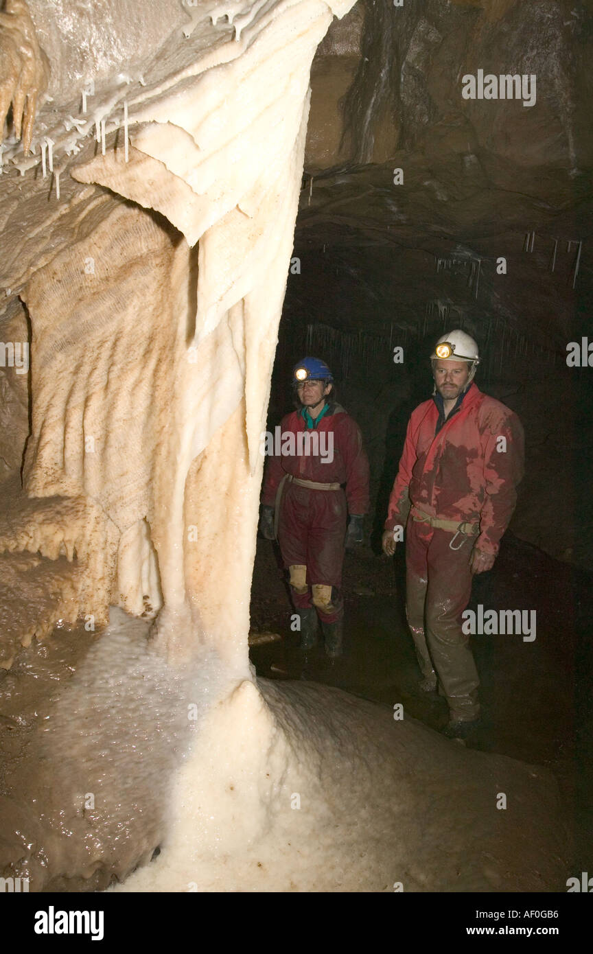 male and female cavers inspect flowstone formations in Notts II cave ...
