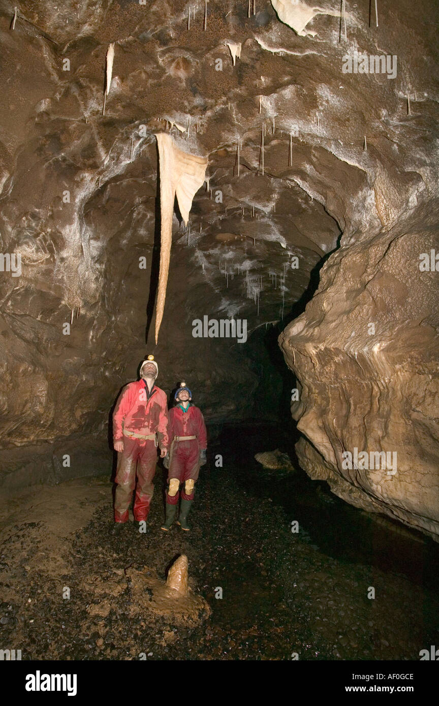male and female cavers in Notts II cave admire formations in a stream ...