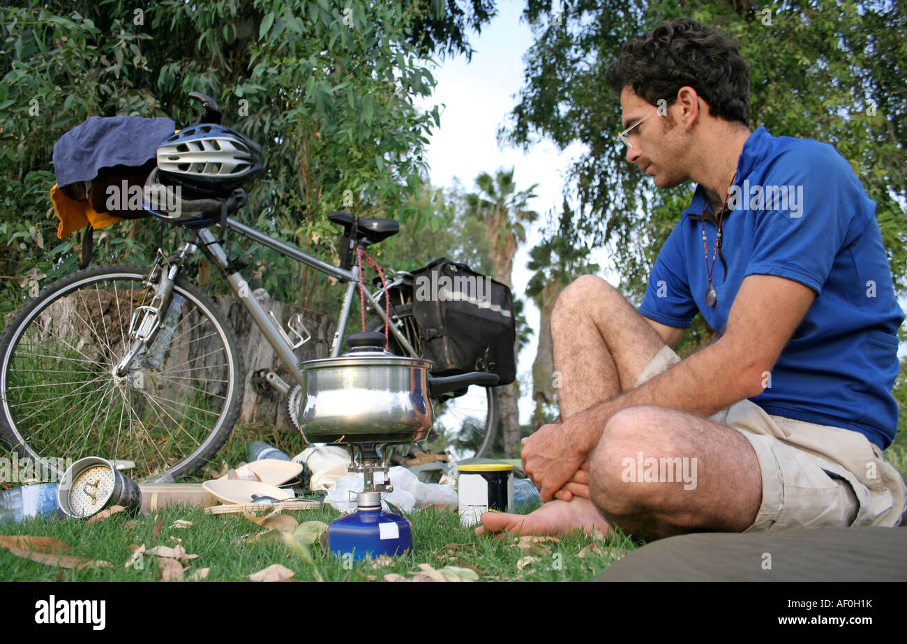 camper sitting cooking next bicycle Stock Photo - Alamy