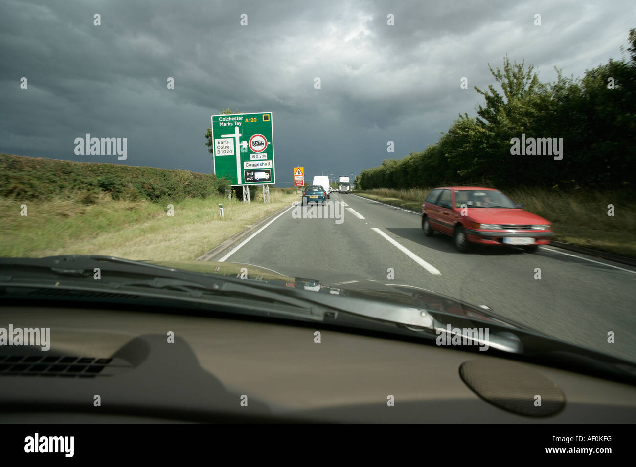 Driving towards stormy weather, view from driver's perspective, England ...
