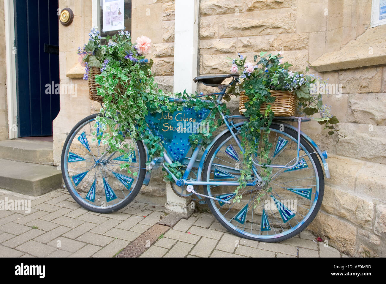 Old blue bicycle decorated with flowers Chipping Campden Cotswolds ...