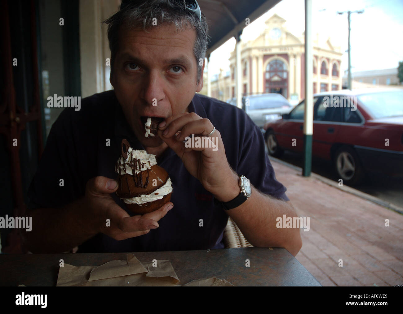 Man eating chocolate cake at al fresco street cafe Stock Photo - Alamy