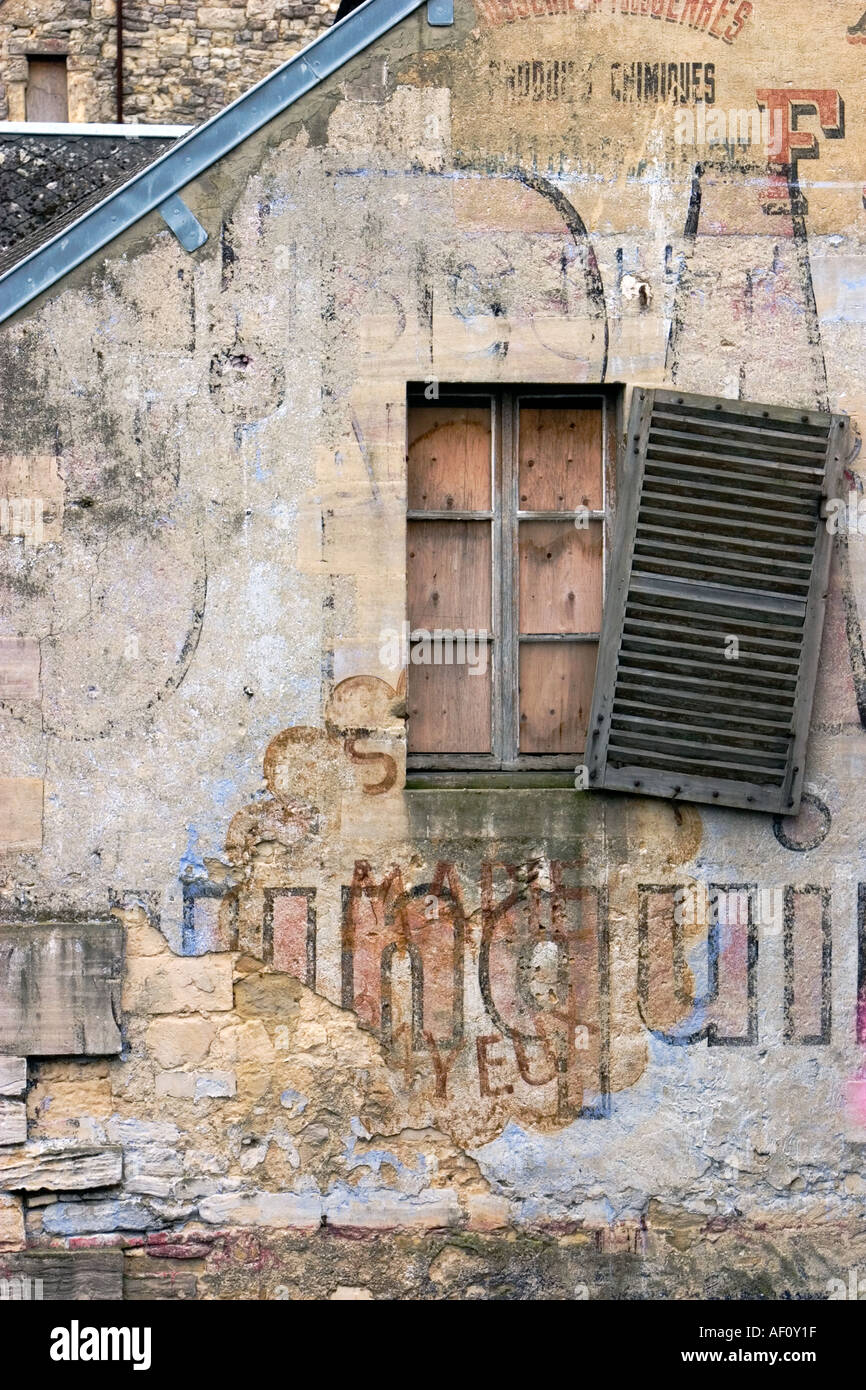 Dilapidated building with boarded up window broken shutter and faded ...