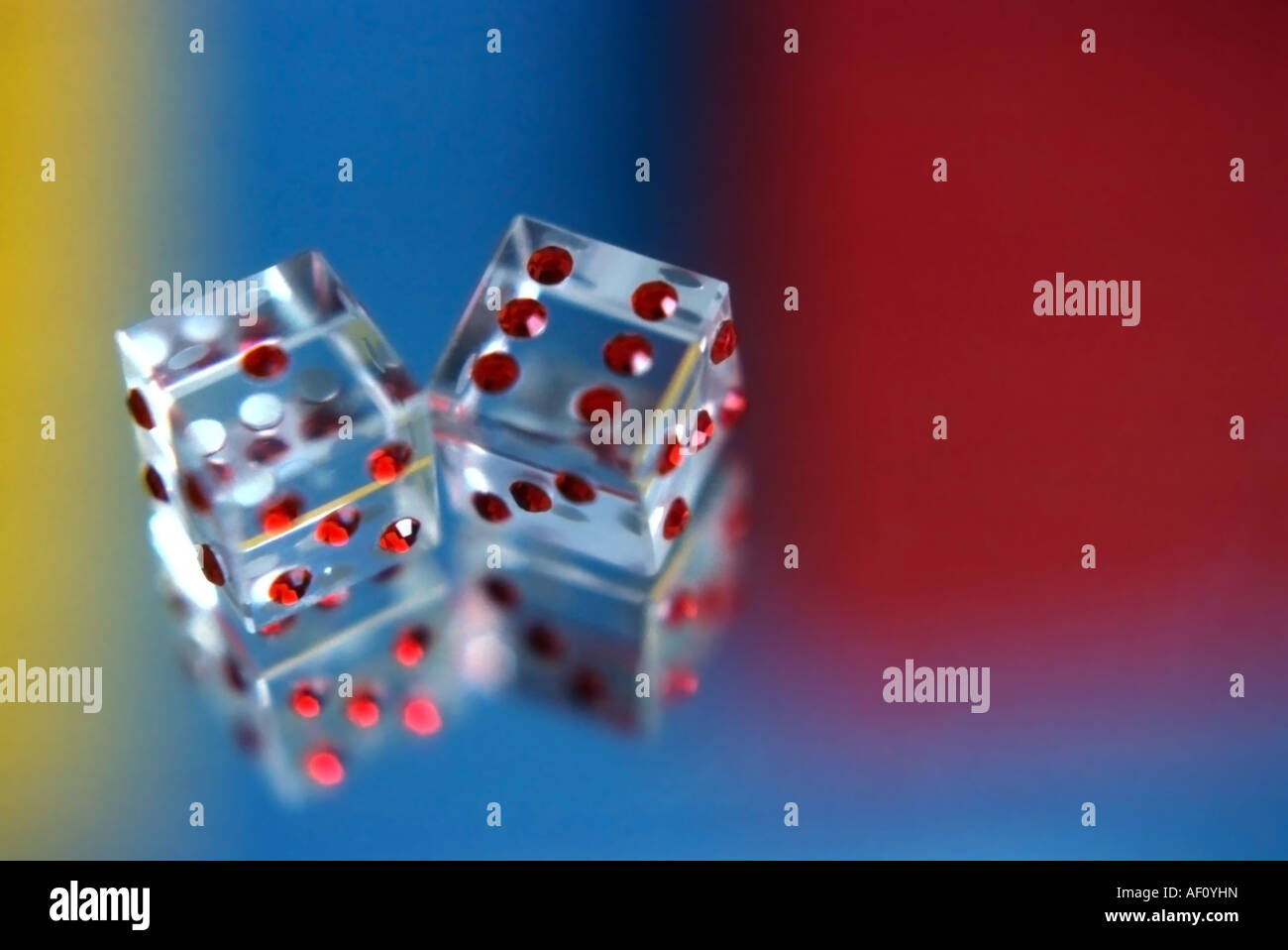 A still life conceptual image, using crystal dice on a colored mirror ...