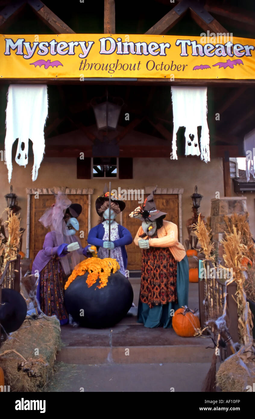 Three old witches stir a boiling brew in a huge pot in front of a ...