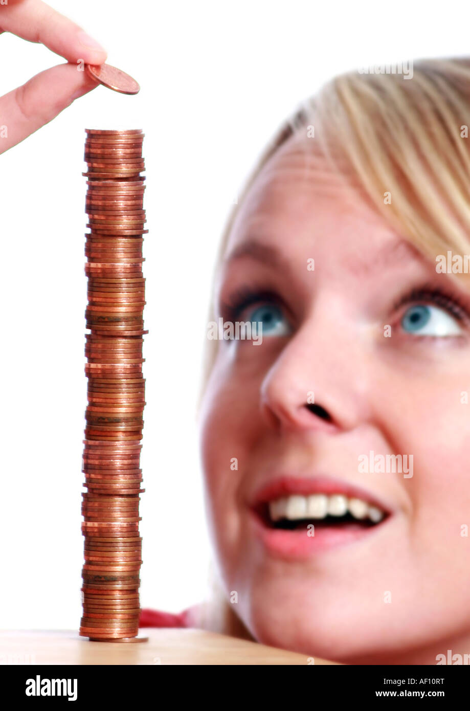 woman building a high stack of pennies Stock Photo - Alamy