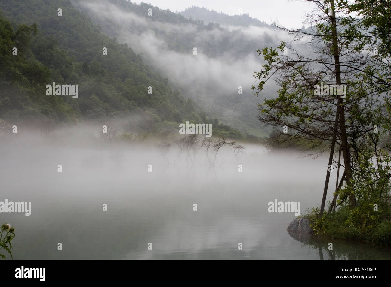 A lake shrouded in mist in the heart of the Min Mountains in Sichuan ...