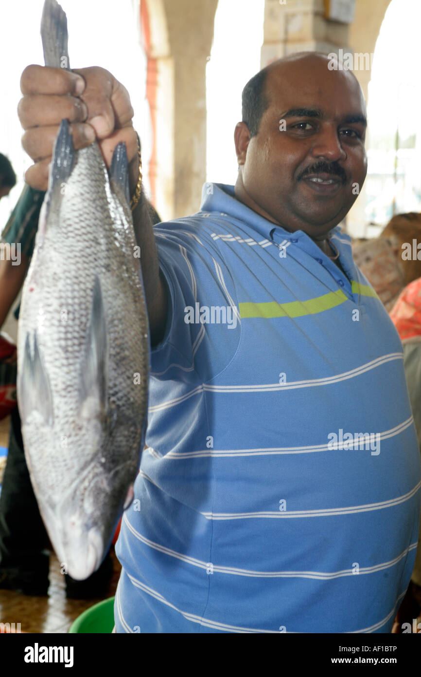 A Goan fishmonger showing off a fresh fish on fishmarket in Margao ...
