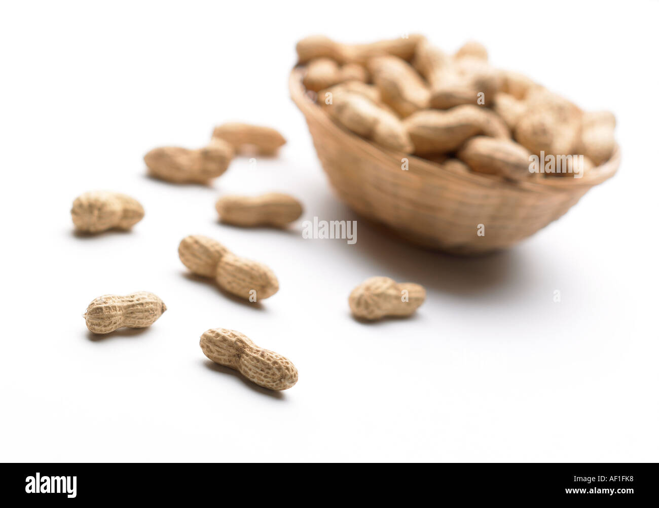 Landscape shot of peanuts in basket on white background Stock Photo - Alamy