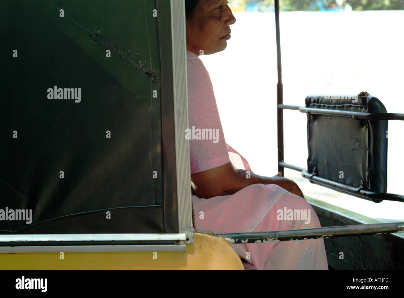 A woman sits and waits for the rickshaw driver to return to the ...
