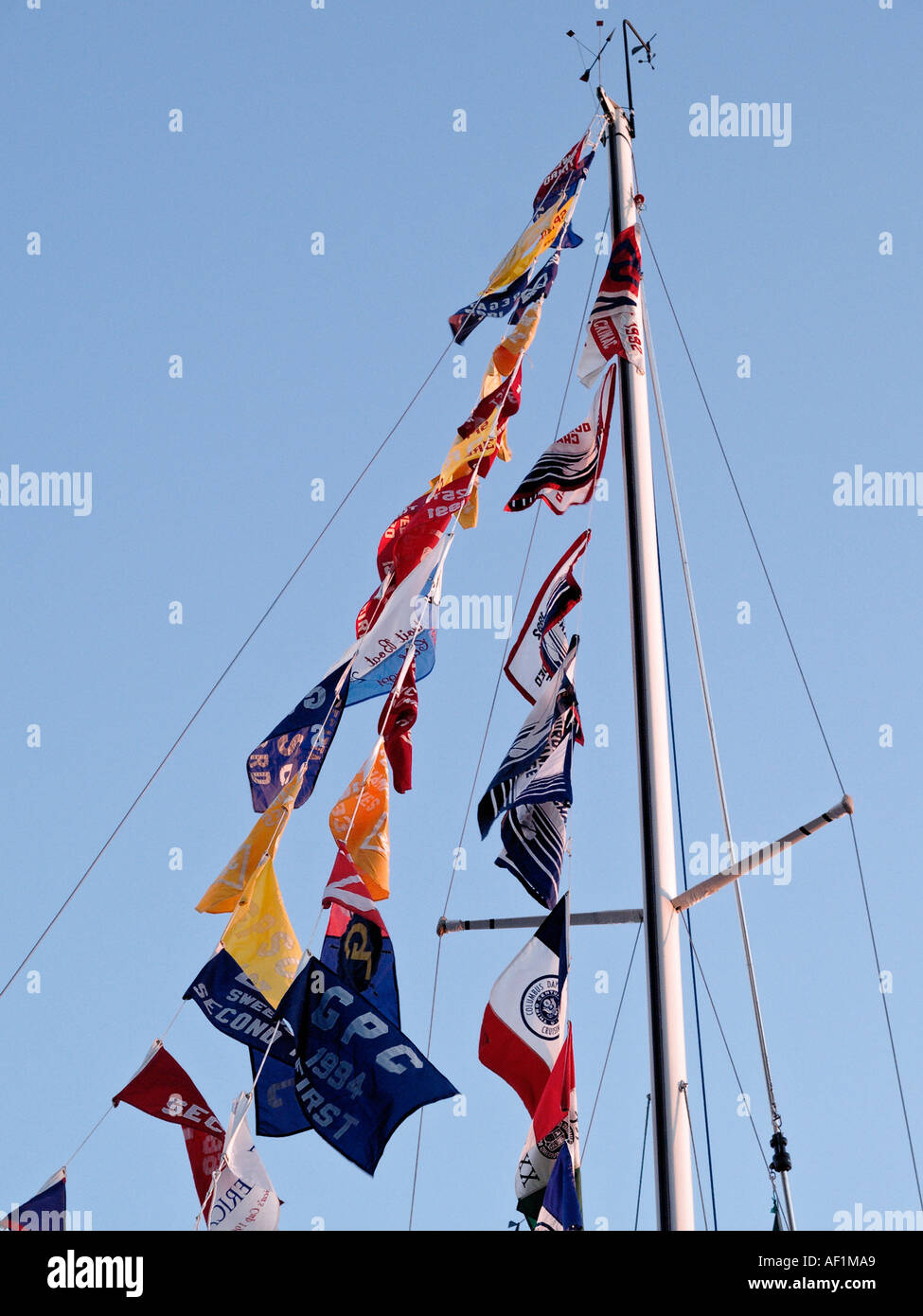 Flags flying from the mast of a sailboat against a clear blue sky Stock ...