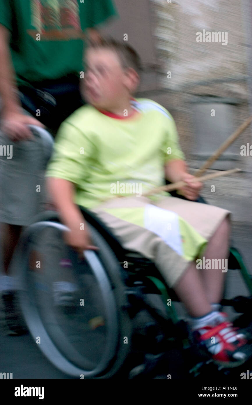 blurred image of young invalid kid boy in wheelchair in street Stock ...