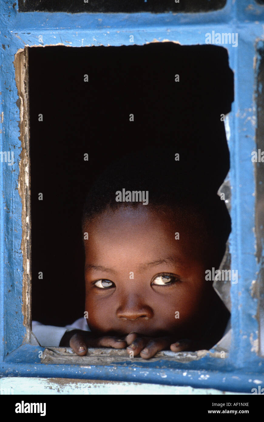 South Africa, Capetown, Child behind a broken window in the Township of ...