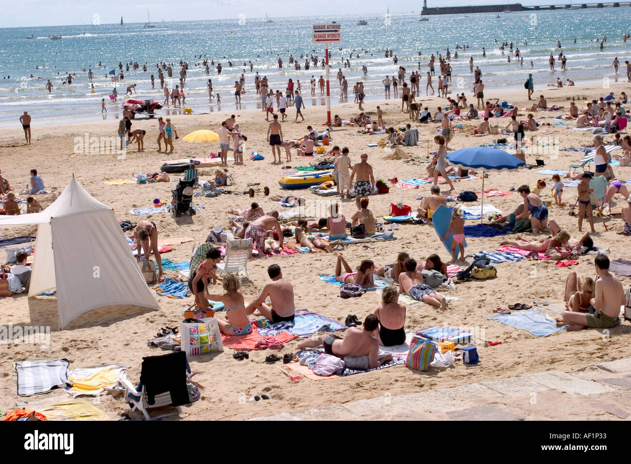 people on a white sandy beach sun tanning and enjoying themselves ...