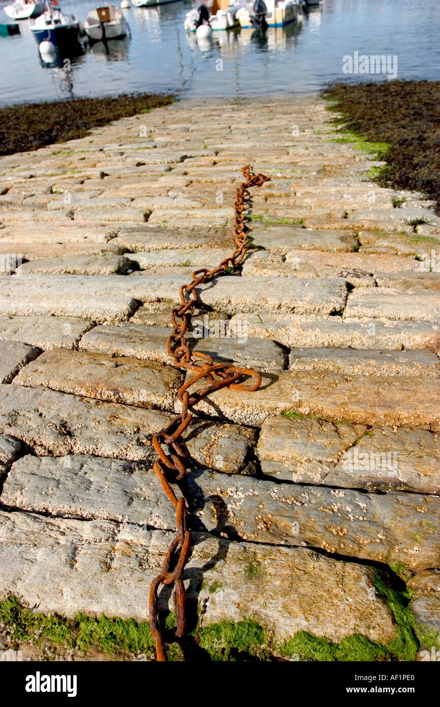 abandoned chains on rocks of pier with water of sea in back Stock Photo ...