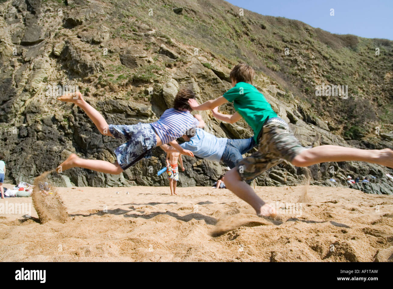 teenage boys playing catch on beach Stock Photo - Alamy