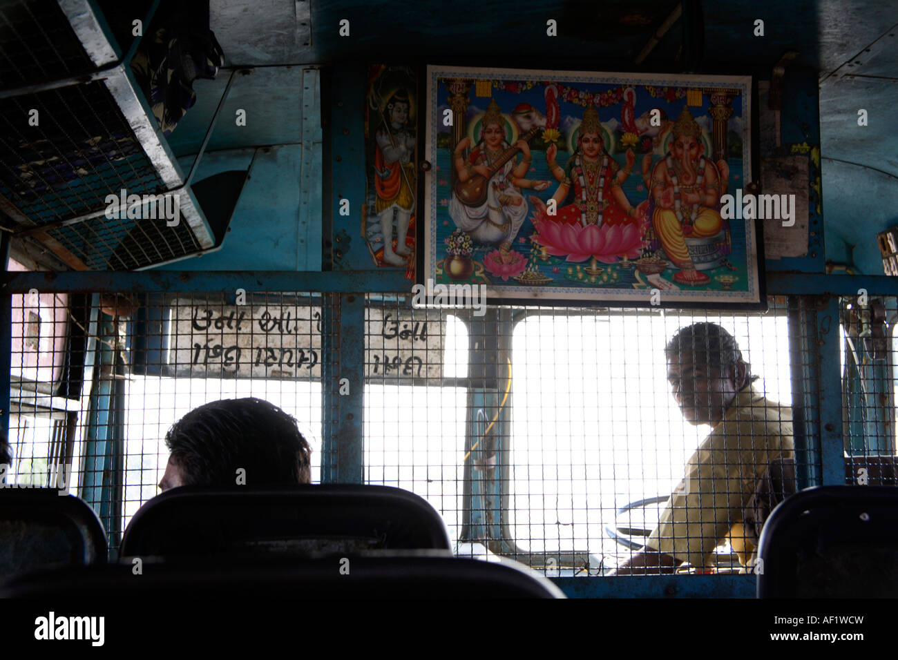 Indian Bus driver seated in enclosed area behind metal grill at front ...