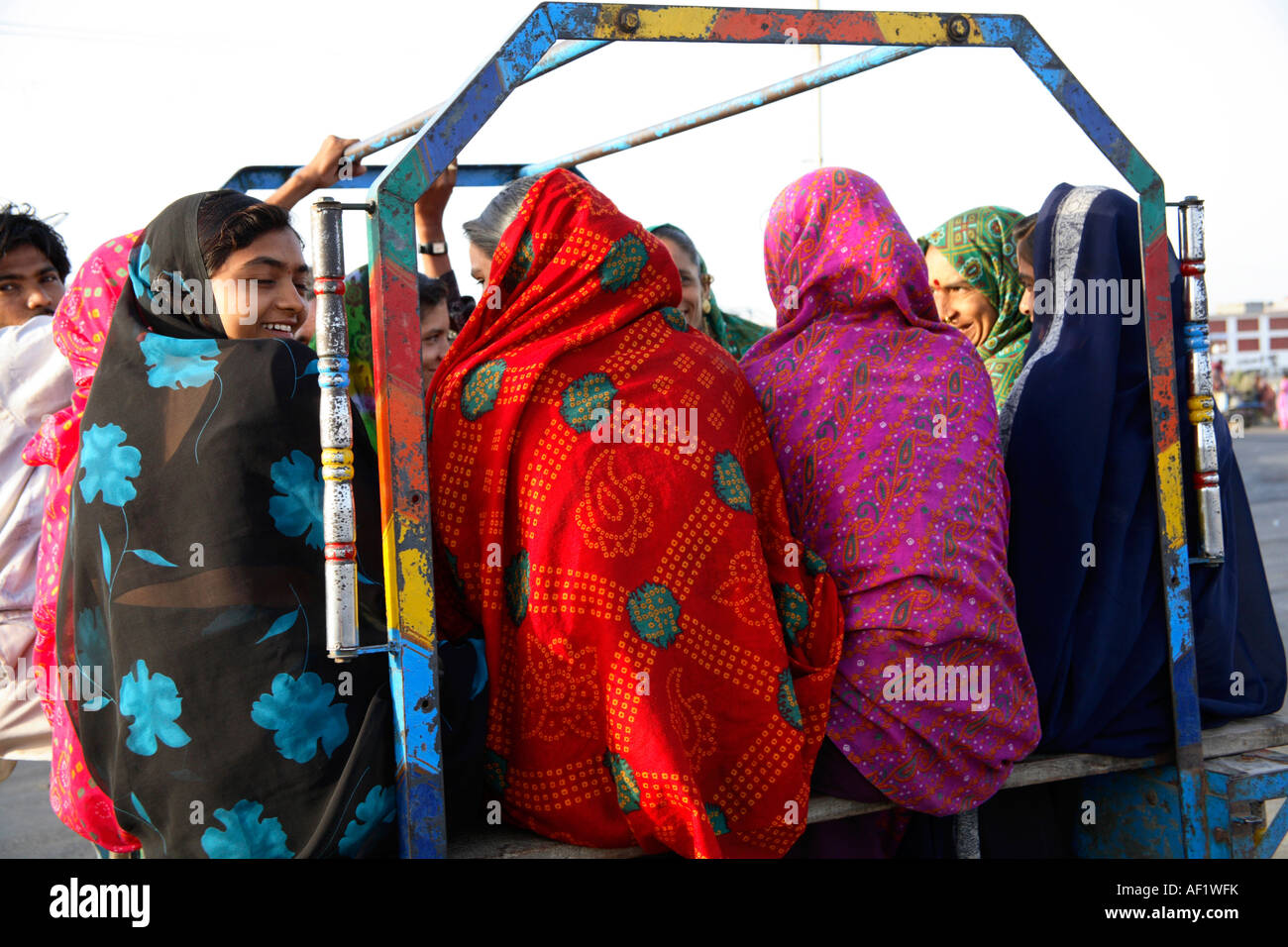 Indian females going to work in rear of chakda - motorbike rickshaw ...