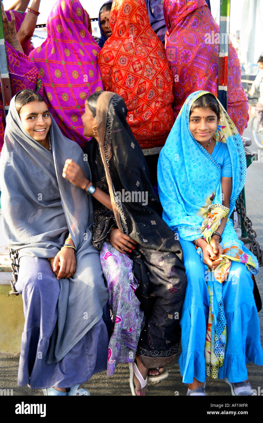 Young Indian women going to work in rear of chakda - motorbike rickshaw ...