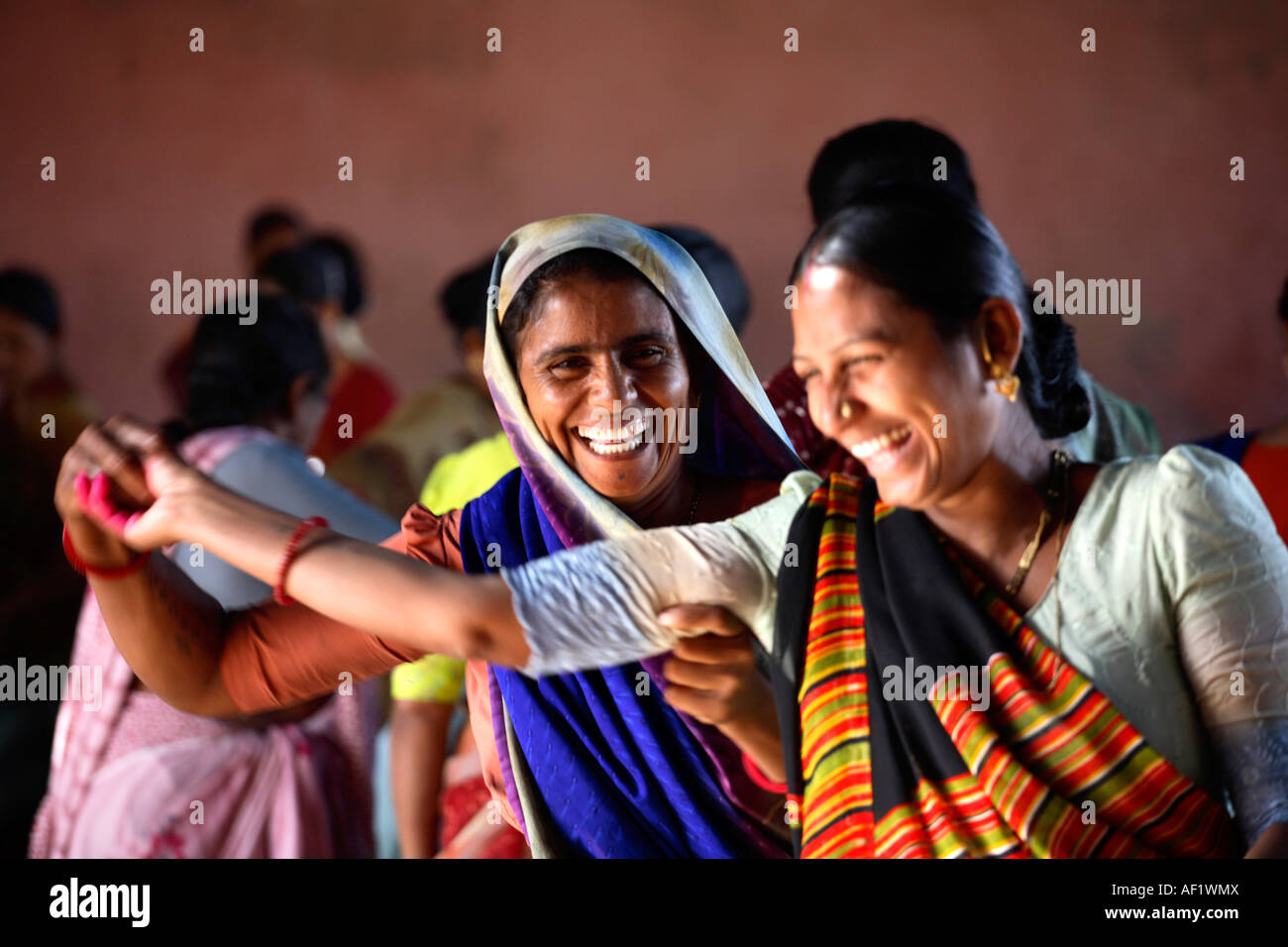 Laughing Indian woman trying to persuade her friend to pose for ...