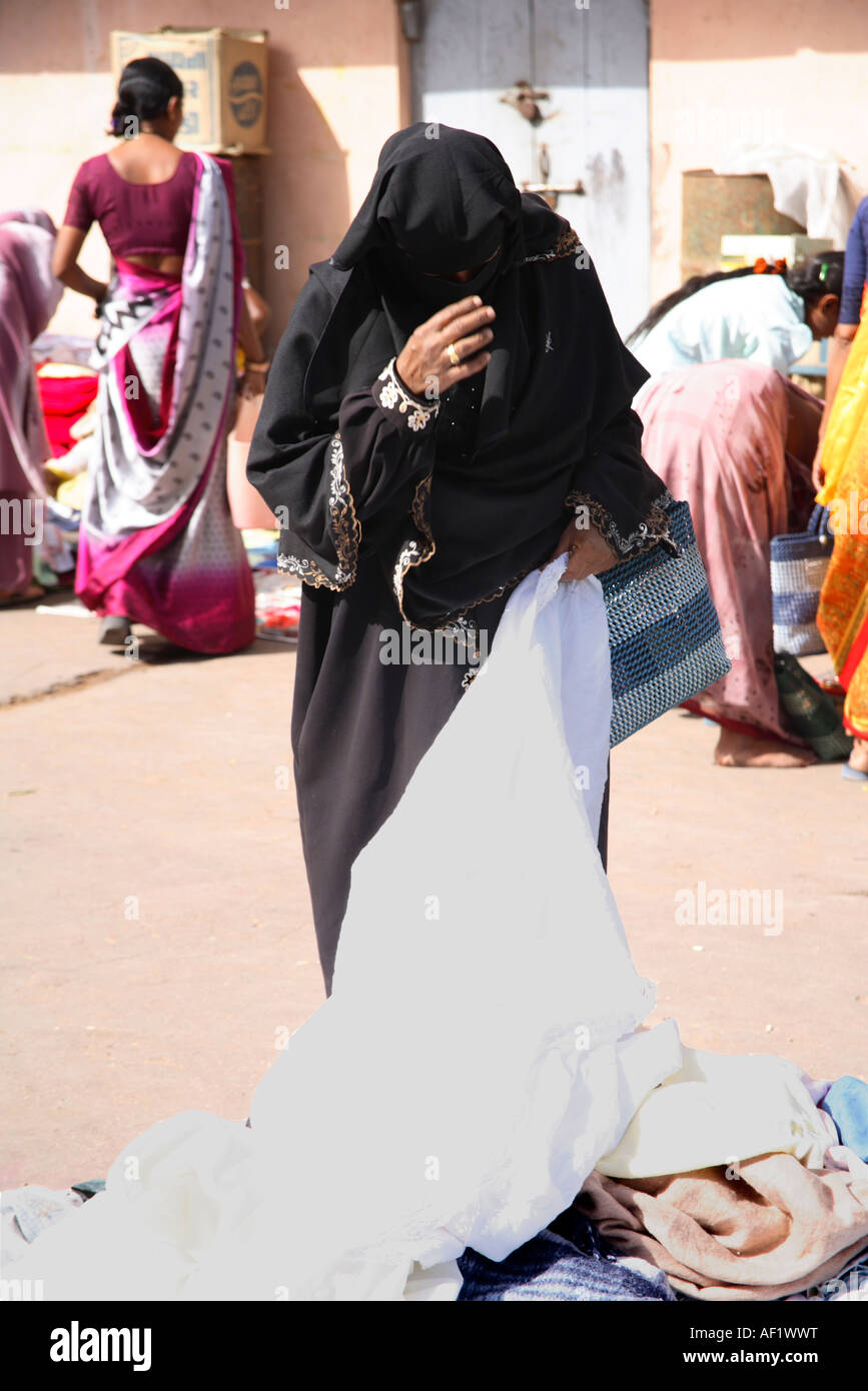 Indian muslim female wearing niqab shopping for material laid out on ...