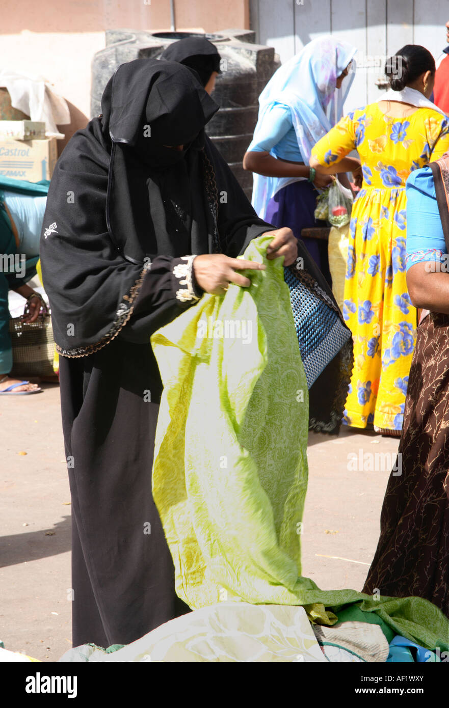 Indian muslim female wearing niqab shopping for material laid out on ...