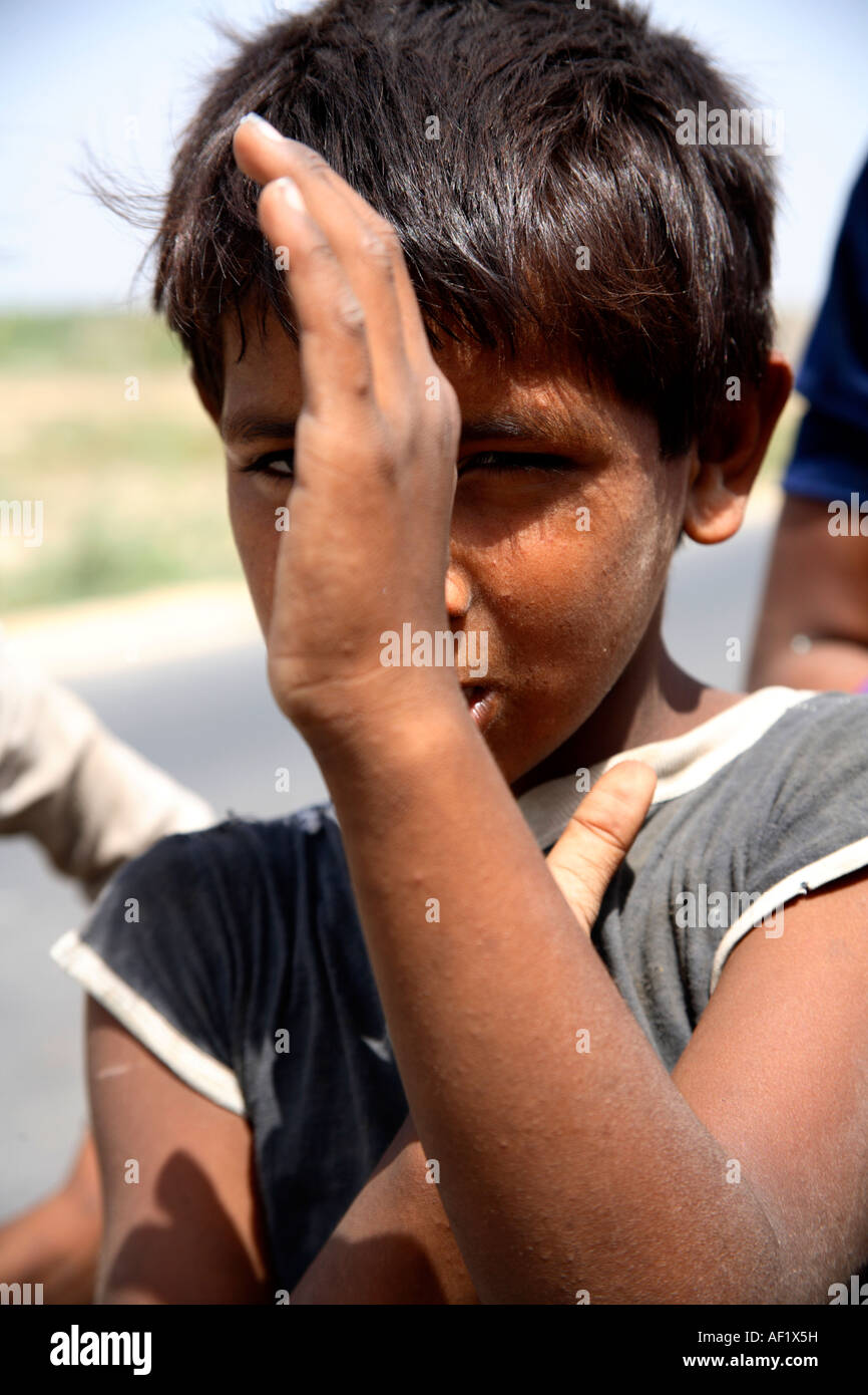 Young Indian street kid with half face hidden performs karate stance ...