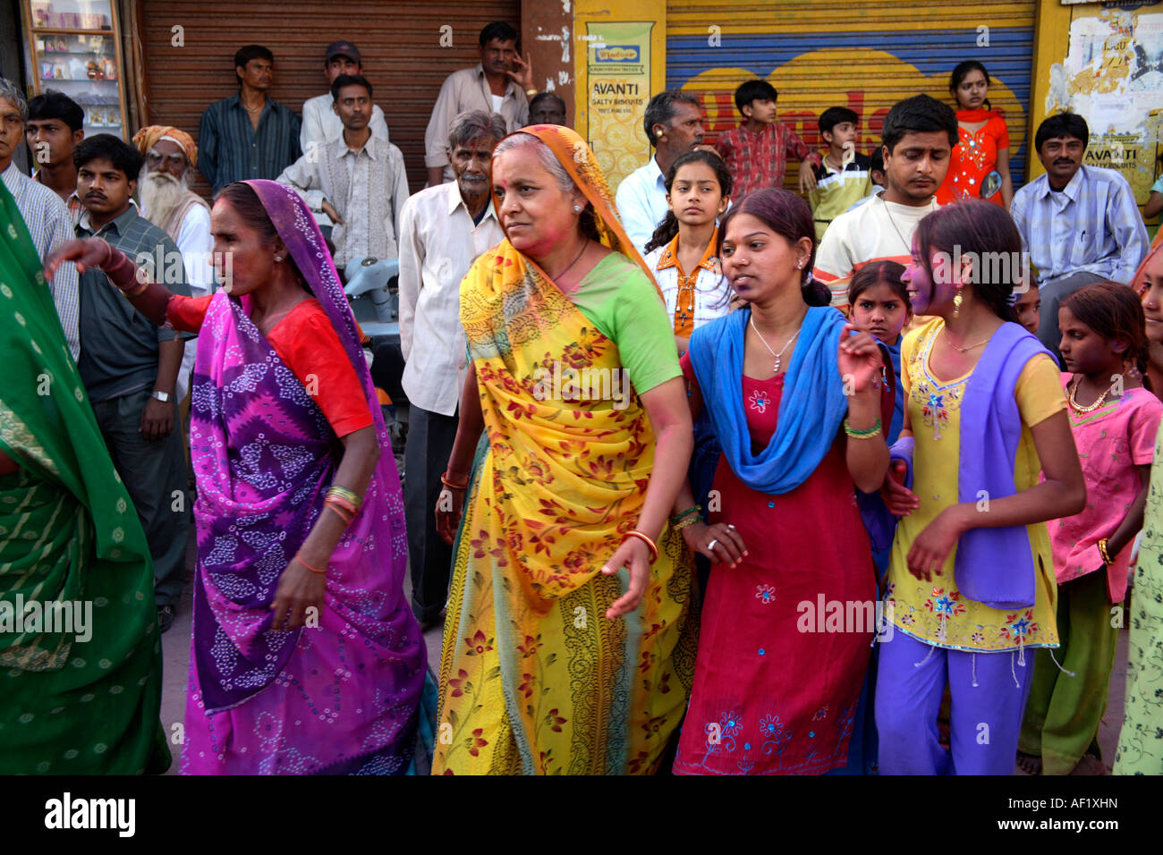 Indian women dancing in the street celebrating holi festival of colours ...