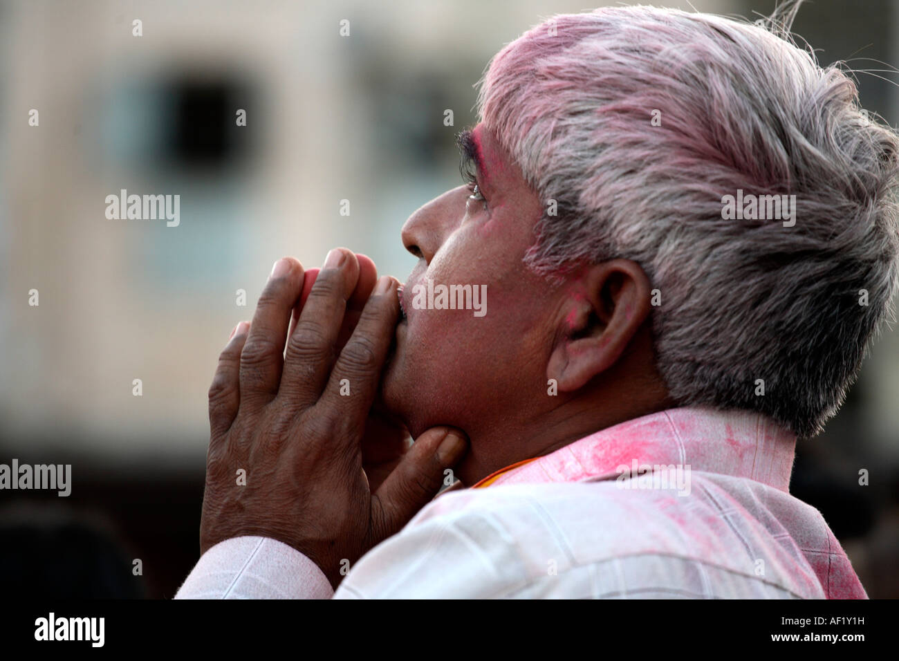 Indian man with coloured powder splattered on hair and clothes ...