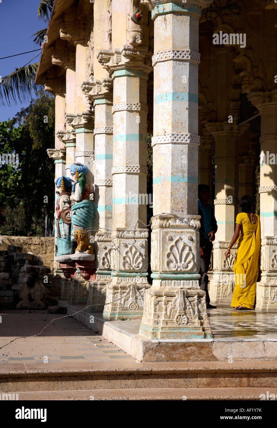 Indian woman walking through beachside ruins of Temple complex ...