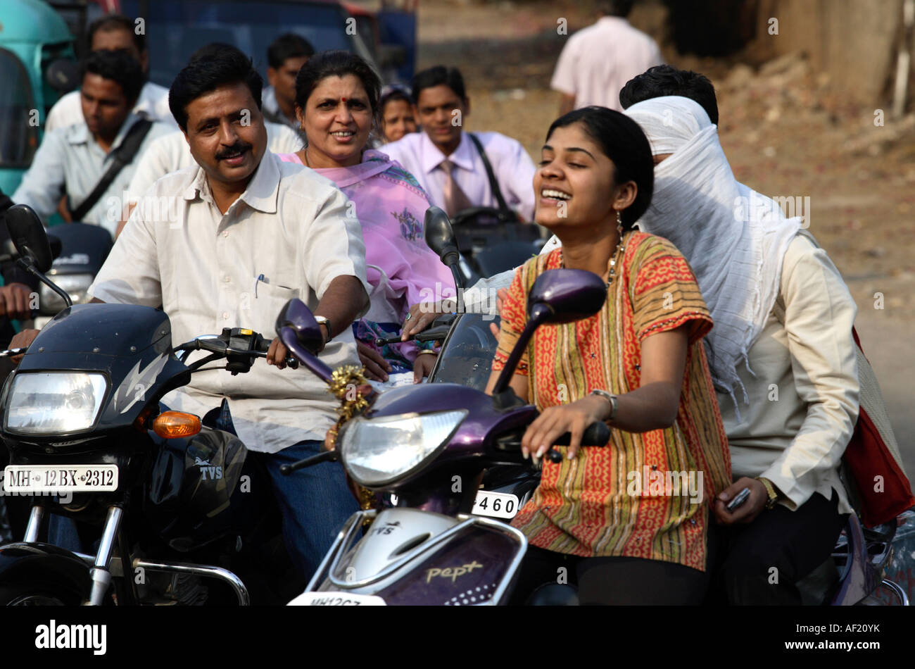 Indian female riding scooter without crash helmet in busy traffic, Pune ...