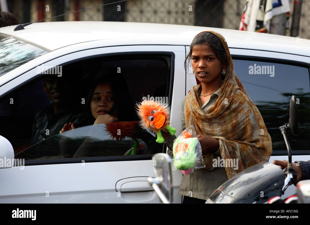 Young girl selling glove puppet in busy traffic, Pune, India Stock ...
