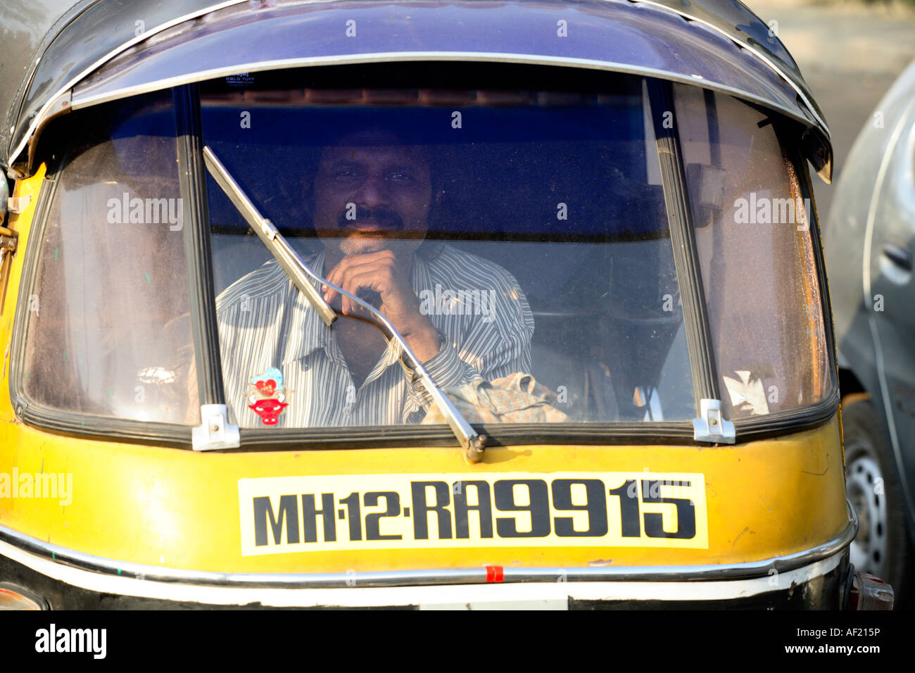 Auto rickshaw driver peering through windscreen whilst seated in ...