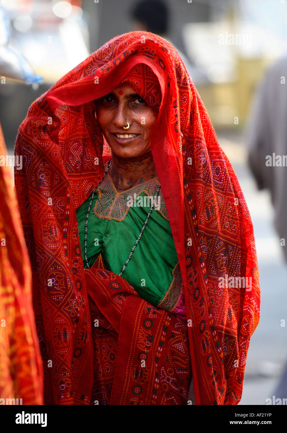 Rabari Tribal woman with neck tattoos shielding face from sunlight, Una ...