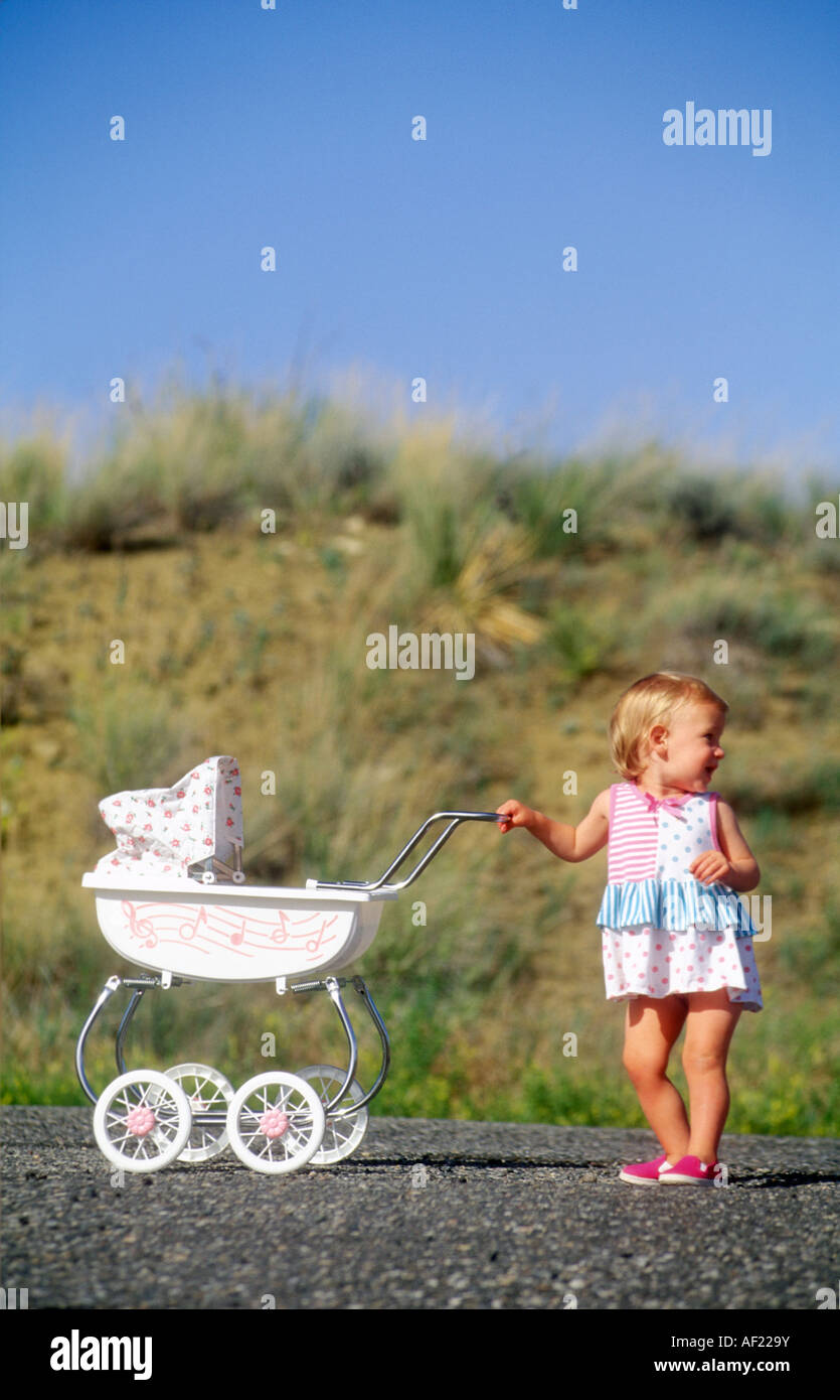 Little girl with baby carriage Stock Photo - Alamy
