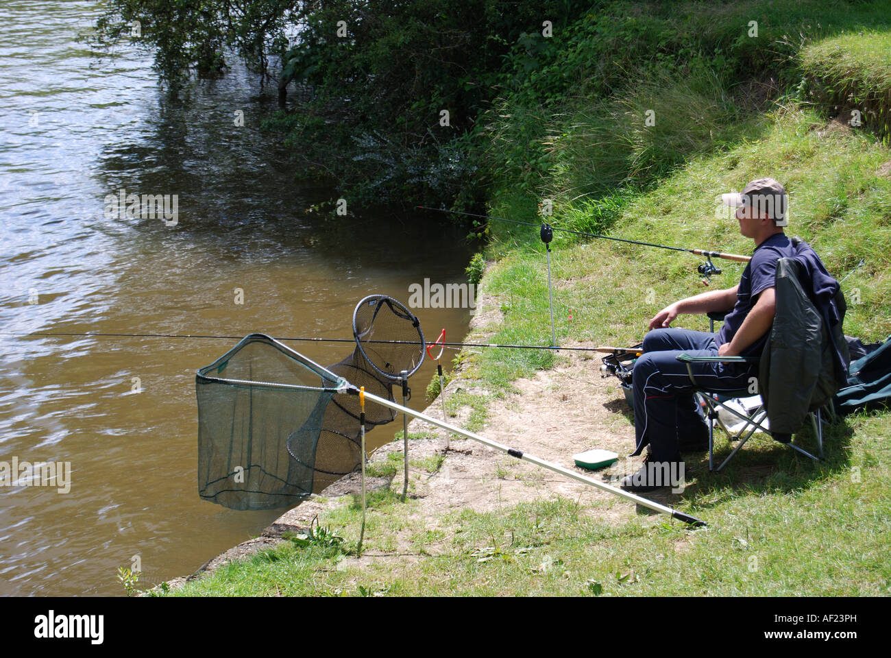 Man fishing on banks of River Thames, Runnymede, Surrey, England ...