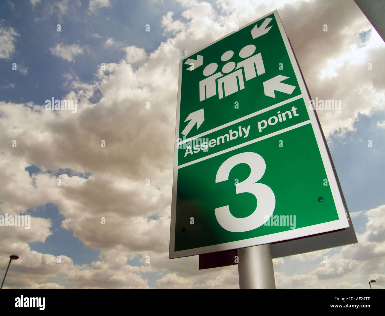 Assembly point sign post at a place of work Stock Photo - Alamy