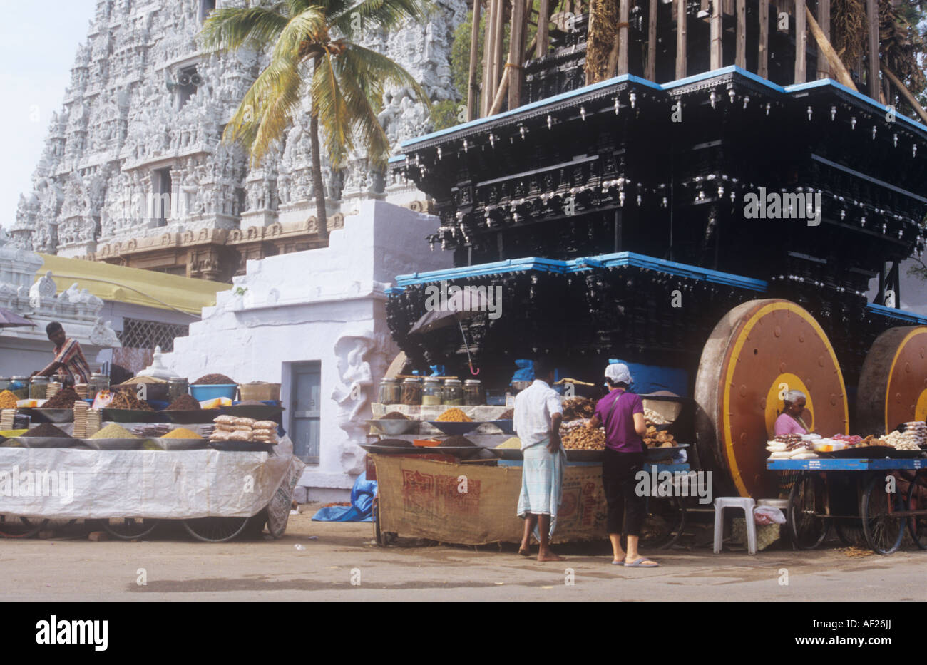 A market stall set up in front of a chariot used for religious parades ...