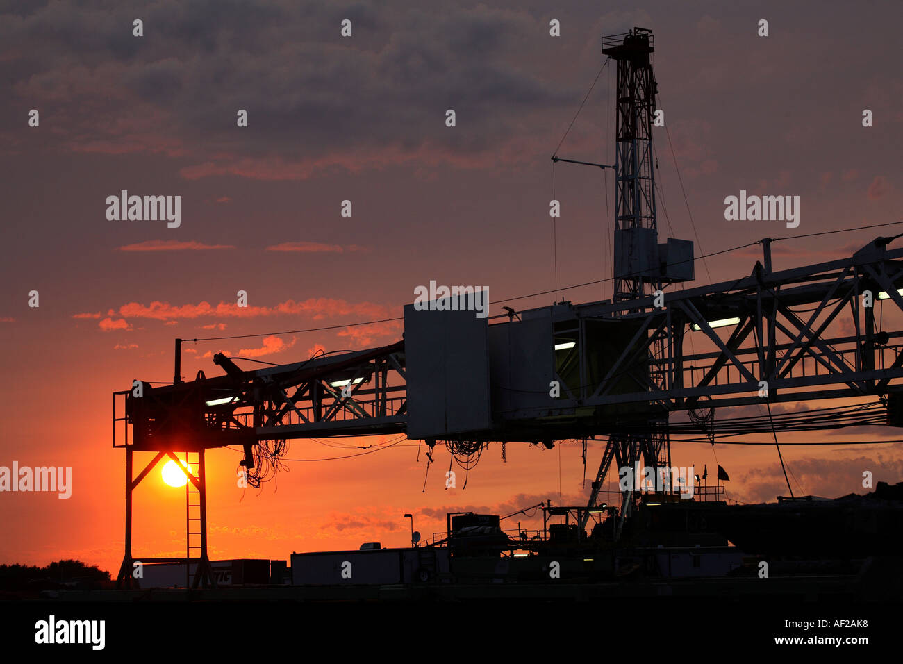 Sun setting behind Mission Oil drilling rig and pump jack in the ...