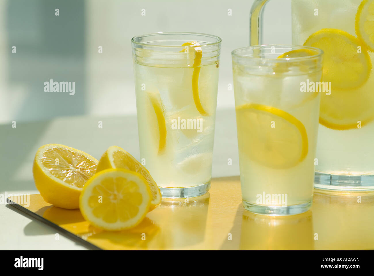A sunlit pitcher and glasses full of fresh lemonade, bathed in sunlight ...