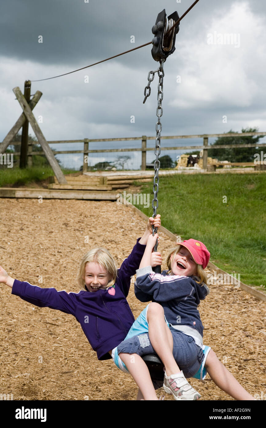 Two girls on zip wire enjoying themselves Stock Photo - Alamy