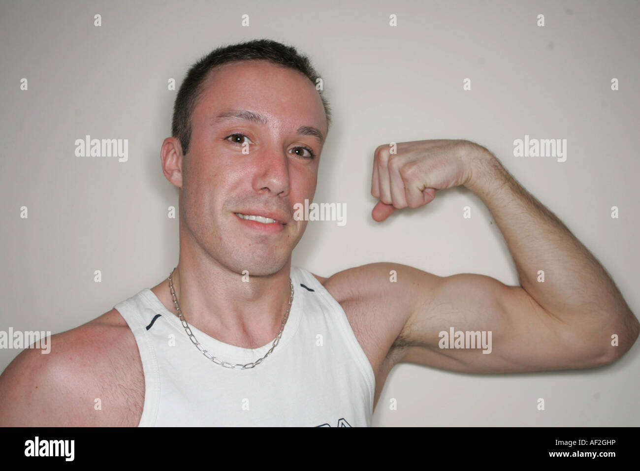 A young man flexes his muscles Stock Photo - Alamy